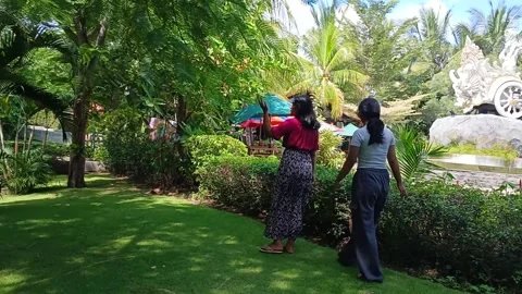 Two teen girls walk casually on grass pa... | Stock Video | Pond5