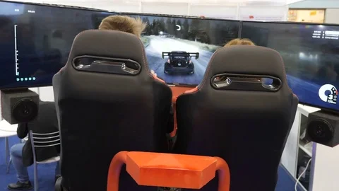 Two teenagers are playing a racing simul... | Stock Video | Pond5