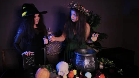 Two witches pose standing next to a tabl... | Stock Video | Pond5