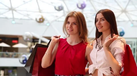 Two women with purchases look away in mo... | Stock Video | Pond5