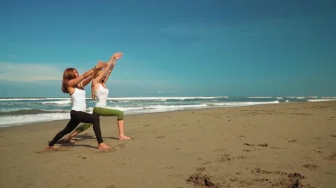 Two women raising hands into warrior yog... | Stock Video | Pond5