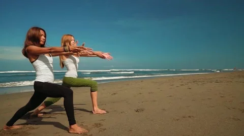 Two women raising hands into warrior yog... | Stock Video | Pond5