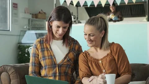 Two women talking while using a laptop s... | Stock Video | Pond5