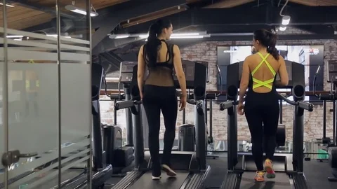 Two women warm up in running machine in ... | Stock Video | Pond5