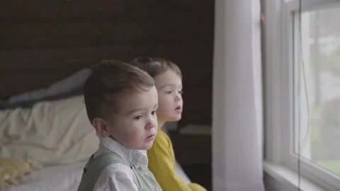 Two Young Boys Look Out the Window Toget... | Stock Video | Pond5