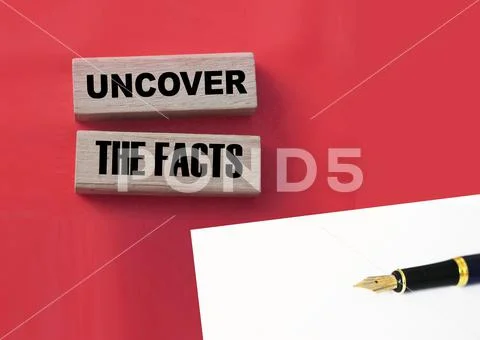 Uncover the facts word wood blocks on red. Fake or real news concept ...