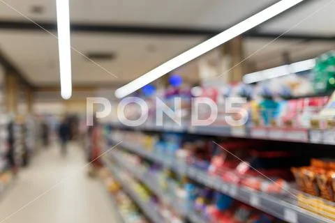 Unfocused shot of supermarket interior. Blurry hypermarket, mall or ...