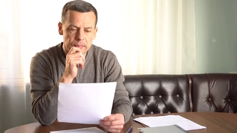 Unhappy sad man reading letter, bill, ba... | Stock Video | Pond5