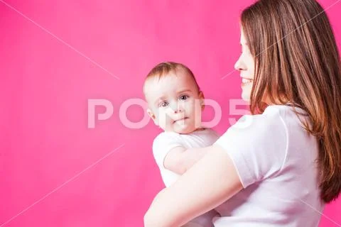 Unity of mother and child The happy mom shows her baby at camera ,model ...