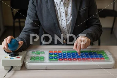 Photograph: An unrecognizable woman with cerebral palsy is typing on ...