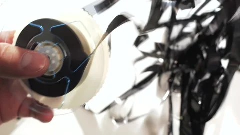 Unspooling the VHS tape from the reel in... | Stock Video | Pond5