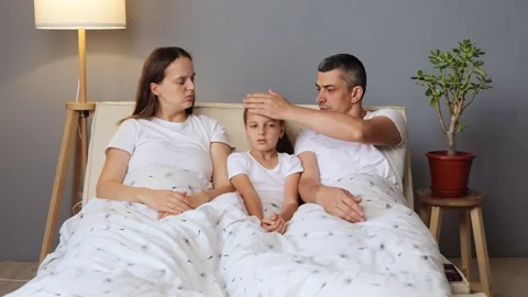 Unwell little girl lying in bed with her... | Stock Video | Pond5