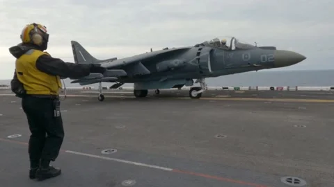 U.S. aircraft handler signalling to AV-8... | Stock Video | Pond5