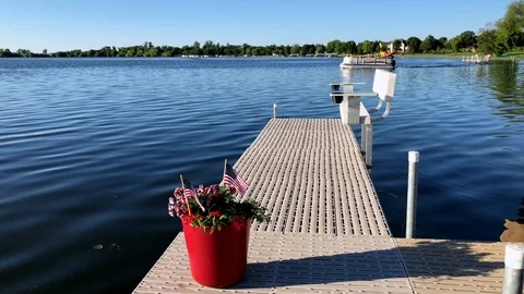 US flags and red flowers in pot on a boa... | Stock Video | Pond5