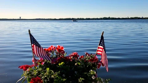 US flags and red flowers in pot on a boa... | Stock Video | Pond5