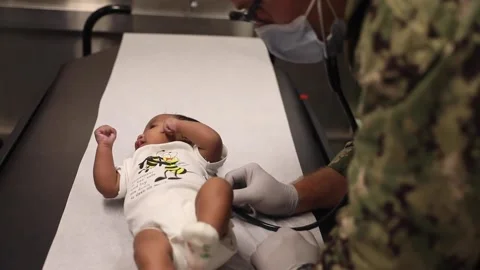 U.S. Navy medic using stethoscope on bab... | Stock Video | Pond5