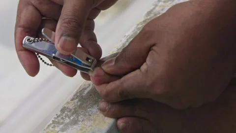 Using a nail clipper to cut the toenails... | Stock Video | Pond5