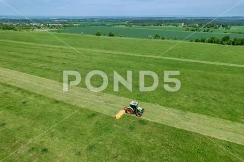 Using a rotary mower, tractor efficiently trims grass. Top view of ...