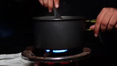 Using a spoon to stir food cooking atop ... | Stock Video | Pond5