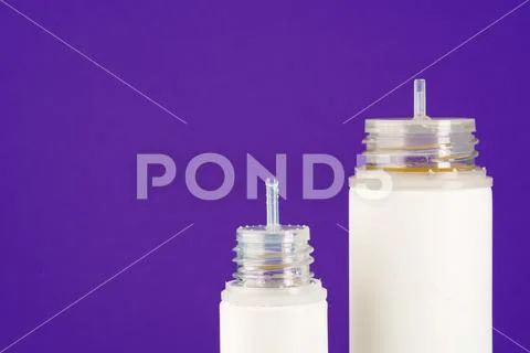 Vape liquid dripping with cap on purple background Stock Image #247721111