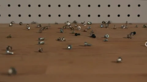Various screws falling onto a workbench ... | Stock Video | Pond5