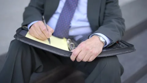 Video pull out of a businessman writing ... | Stock Video | Pond5