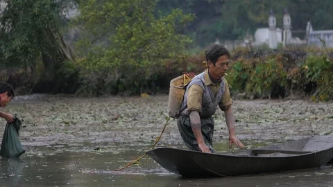 Vietnamese man tipping water out of boat... | Stock Video | Pond5