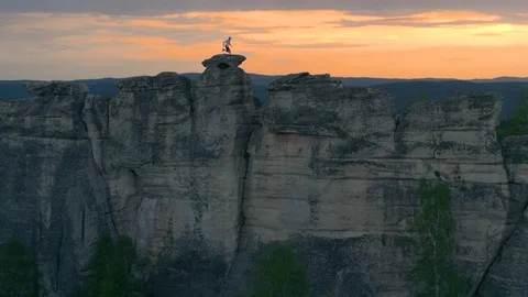 View of man running on cliff in sunset | Stock Video | Pond5