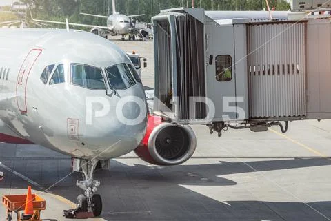 View of the nose and cockpit of the aircraft and the docking gangway ...