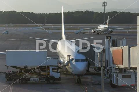 View of the nose and cockpit of the aircraft and the docking gangway ...