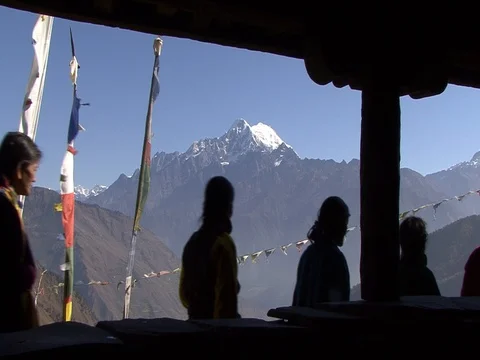 Villagers walk past prayer flags with Hi... | Stock Video | Pond5