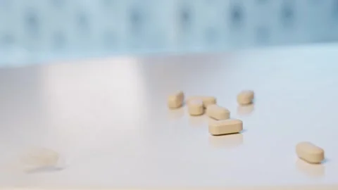 Vitamin tablets falling down on white su... | Stock Video | Pond5