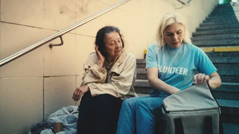 Volunteer sharing a hot meal with sad ho... | Stock Video | Pond5