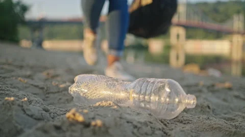 Volunteer walks on sand beach gathering ... | Stock Video | Pond5