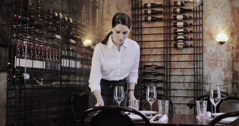Waitress setting a table in a restaurant | Stock Video | Pond5