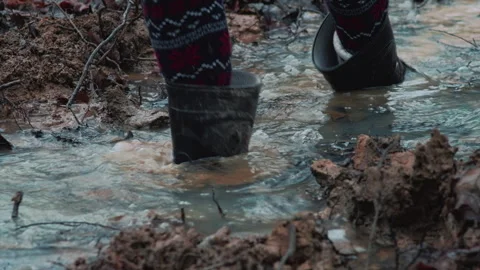 Walking through a deep puddle in rubber ... | Stock Video | Pond5