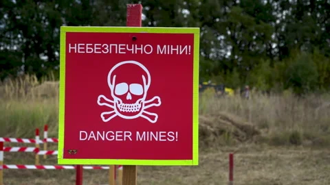 A warning sign about mines in an open fi... | Stock Video | Pond5