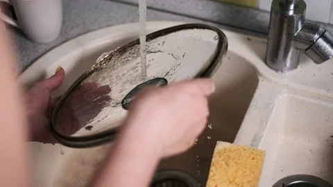 Washing a Glass Lid in the Kitchen Sink | Stock Video | Pond5