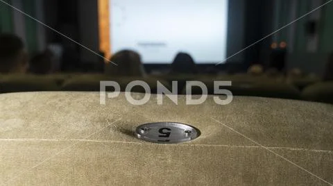 Watching films. Blurred movie on the big screen in the cinema and chair ...