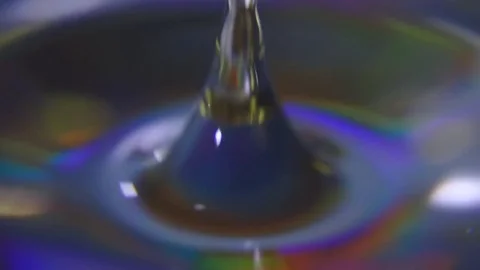 Water drop falls on the colorful surface... | Stock Video | Pond5