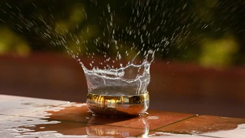 water drop falls fast into small golden ... | Stock Video | Pond5