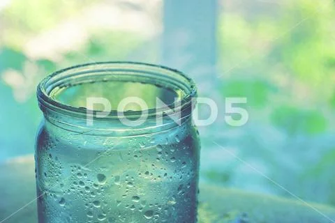 A water drop jar with water on the glass. a can full of water by the ...