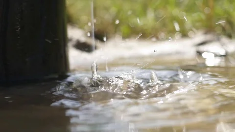 Water droplets fall into puddle with wat... | Stock Video | Pond5