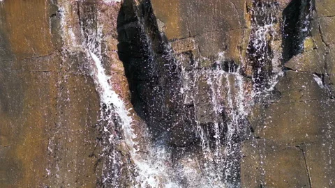 Water falling down from a stone wall in ... | Stock Video | Pond5