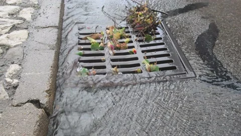Water flows down through the manhole cov... | Stock Video | Pond5