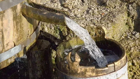 Water pouring into wooden bucket from a ... | Stock Video | Pond5