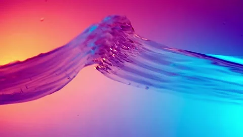 Water splash in slow motion on colorful ... | Stock Video | Pond5