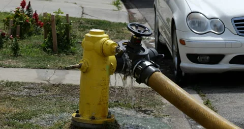 Water spraying from a fire hydrant where... | Stock Video | Pond5