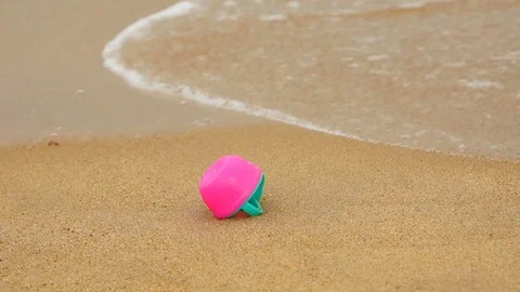 Wave brought a plastic toy on the beach. | Stock Video | Pond5