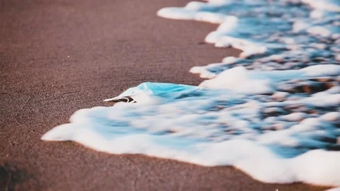 The waves drag away a mask lying on the ... | Stock Video | Pond5